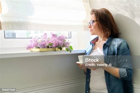 차 한 잔과 라일락 꽃다발 복사 공간 창 근처에 서있는 여성 창문에 대한 스톡 사진 및 기타 이미지 창문 한 명의 여자만