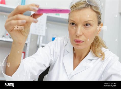 Mature Female Scientist Inspecting Pink Liquid In Test Tube Stock Photo Alamy