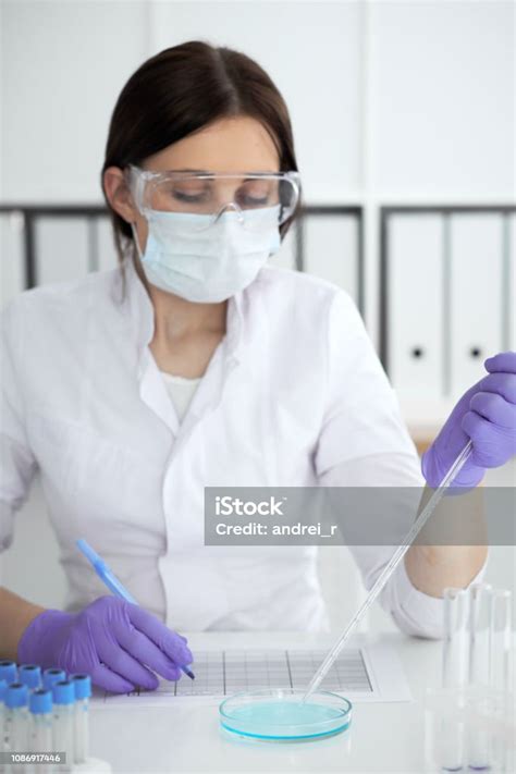 실험 시 약 또는 혈액을 실험실에서 테스트 하는 보호 안경에 전문 여성 과학자의 클로즈업 의학 생명 공학 및 연구 개념입니다