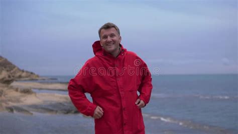 Man In Red Jacket Standing On Beach Looking Up At Sky Stock Footage