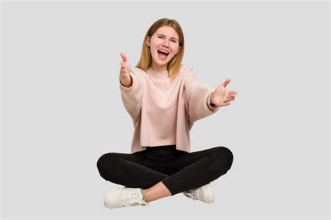 Mujer caucásica joven sentada en el recorte del piso aislado Foto Premium