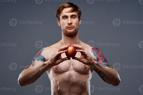 sportlich jung Mann mit muskulös Muskeln und Abs nackt Torso Apfel