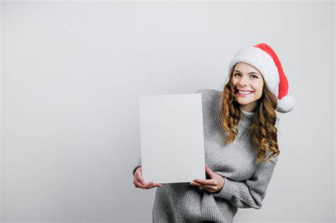 그녀의 손에 흰색 캔버스를 들고 산타 모자소녀 크리스마스 메시지에 대 한 모형 포스터입니다 12월에 대한 스톡 사진 및 기타 이미지 Istock