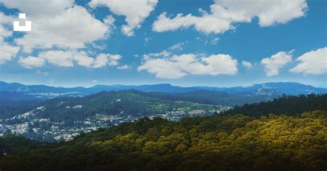 낮에는 푸른 하늘과 흰 구름 아래 푸른 나무와 산 사진 Unsplash의 무료 예쁜 풍경 이미지