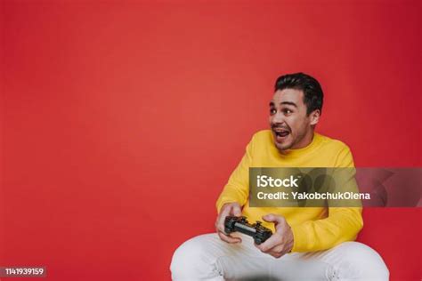 빨간 배경에 조이스틱을 들고 비명 갈색 머리 남자의 절반 길이 Brand Name Video Game에 대한 스톡 사진 및 기타 이미지 Brand Name Video