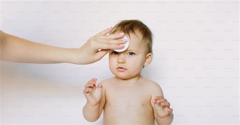 어머니는 흰색 배경에 격리된 뭉친 디스크로 갓 태어난 여자 아기의 얼굴을 청소합니다 위생 의료 개념 사진 Unsplash의 우크라이나 이미지