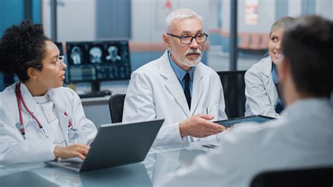 병원 회의 회의실 수석 신경 과학자는 뇌의 Mri 자기 공명 이미지와 태블릿 컴퓨터를 사용 의사의 팀에 이야기 신경과 의사는