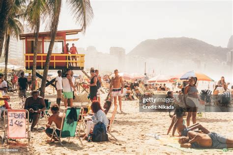 People Relaxing And Sunbathing At Famous Copacabana Beach Rio De