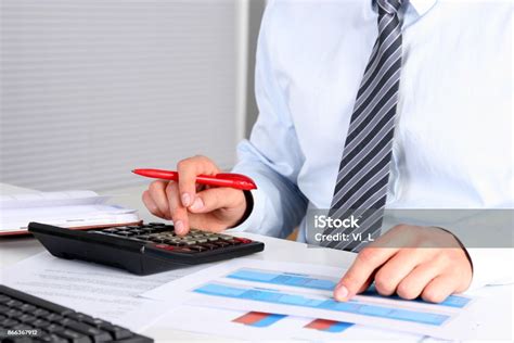 노트북 및 문서에서 보이는 사무실에 테이블에 앉아 밝은 젊은 사업가 기업 재무와 산업에 대한 스톡 사진 및 기타 이미지 기업 재무와 산업 남자 남자 사업가 Istock