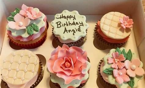 A Box Filled With Cupcakes Covered In Frosting And Decorated To Look Like Flowers