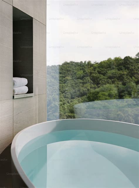 대형 욕조와 창문이 있는 욕실 사진 Unsplash의 벽지 이미지