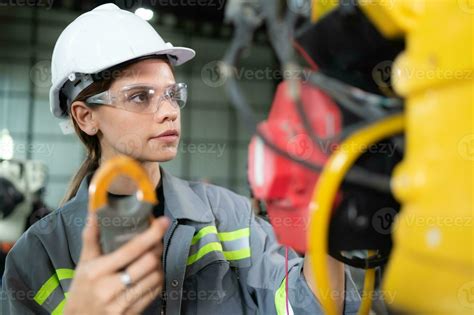 In The Robots Warehouse A Female Engineer Inspects The Electrical