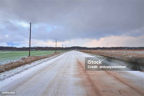들판을 가로지르는 눈 덮인 시골 길 전기 라인 변압기 기둥 차에서 파노라마 보기 다채로운 구름 극적인 일몰 하늘 오프로드 물류 겨울 타이어 외딴 마을 감기와 독감에 대한