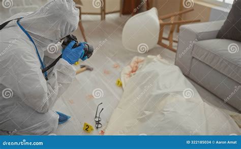 A Man In Protective Forensic Gear Photographs Evidence At A House Crime