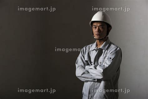 腕組みをする作業員の男性の写真素材 [24599519] イメージマート