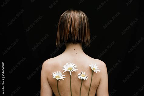 Naked Woman With Chamomiles On Her Back Against Black Background Stock
