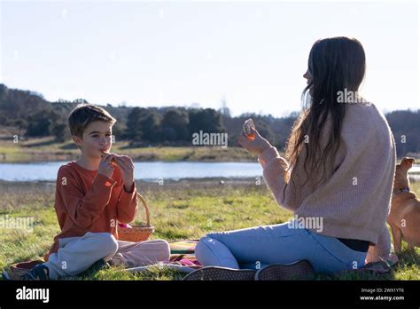 Mother And Son Eating A Sandwich In Nature Dressed In Clothes With Orange Colors Stock Photo Alamy