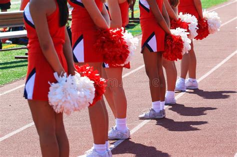 Cheerleaders Holding Their Behind Their Backs On The Sidelines Of A