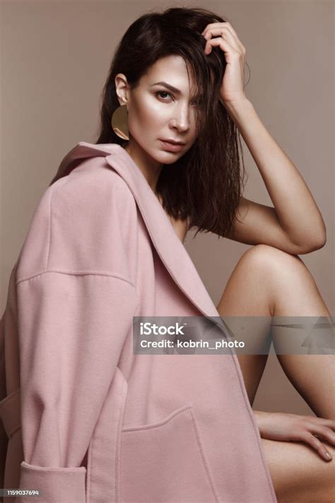 스튜디오에서 포즈를 취하는 트렌디 한 디자이너 코트의 고전적인 메이크업과 헤어 스타일을 가진 아름다운 소녀 뷰티 페이스 개인 장식품에 대한 스톡 사진 및 기타 이미지