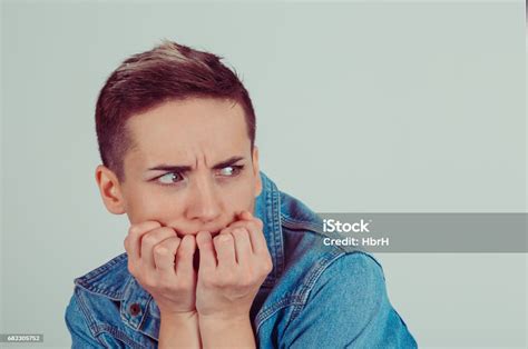 근접 촬영 초상화 젊은 확실 하 게 주저 신경 여 자가 그녀의 손톱 갈망 고립 된 녹색 회색 배경 뭔가 대 한 열망을 물고 부정적인 인간의 감정 얼굴 표정 느낌 신체 언어