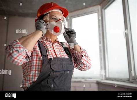 Female Construction Worker With Helmet Headphones Wearing Face Mask Stock Photo Alamy