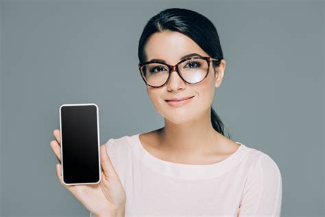 보여주는 스마트폰 빈 화면에 손에 고립 된 화이트 안경에 아름 다운 갈색 머리 여자의 초상화 보여주기에 대한 스톡 사진 및 기타