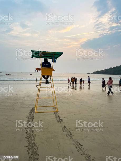 해변 인명 구조원의 클로즈업 이미지는 인도 고아의 팔로렘 해변의 바다와 해안선을 바라보는 인명 구조원 관찰 의자에 앉아 있었다