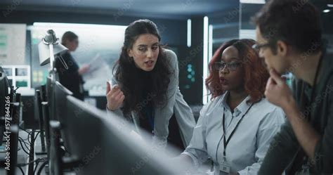 Team Of Three Talented Young Software Engineers Use Computer To Discuss