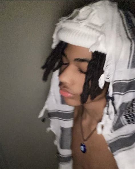 A Young Man With Dreadlocks And A White Towel On Top Of His Head