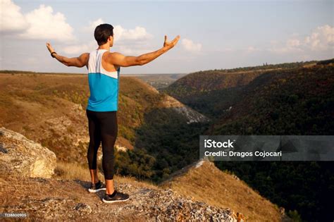 운동 선수의 뒤 근육 질 적합 복 근 젊은 남자는 부분을 통해 손으로 스트레칭 운동을 하 고 숲에서 외부 운동 하기 전에 산 배경 여름 풍경입니다 가로등에 대한 스톡 사진