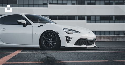 주차장에 주차된 흰색 스포츠카 사진 Unsplash의 무료 기계 이미지