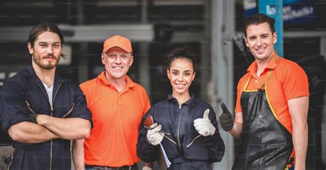 제복을 입은 전문 엔지니어 동료인 팀워크 컨셉의 엄지손가락을 치켜들고 차고 앞에서 밀링하는 정비사 팀의 초상화 단체 사진 사진 Unsplash의 사업 이미지