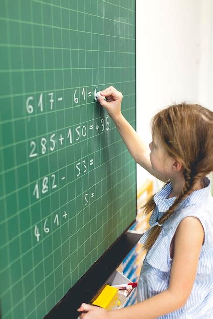 Premium Photo Girl Solving Mathematics Equation On Blackboard In Classroom At School