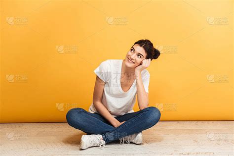 一个微笑的年轻女子的肖像坐着，双腿交叉