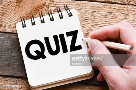 Word Quiz Written In A Notebook On A Wooden Background High Res Stock