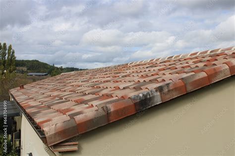 Toiture en tuiles canal ou romane et gouttière en zinc Photos Adobe Stock