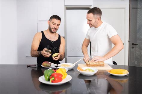 Gay Couple Cooking Healthy Vegan Food Together At Home Stock Image