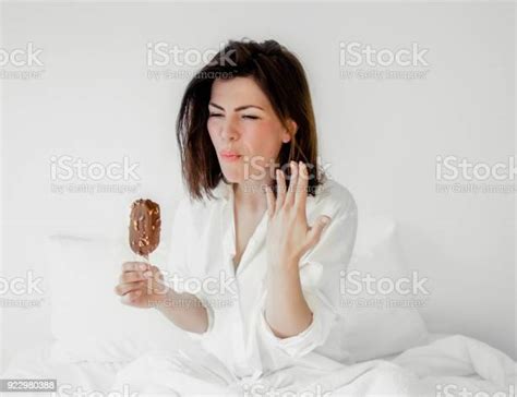 행복 하 게 웃는 젊은 여자는 침실에서 아이스크림을 먹는 흰색 짧은 짧은 검은 머리와 아름 다운 백인 여자 그녀의 방에서 큰