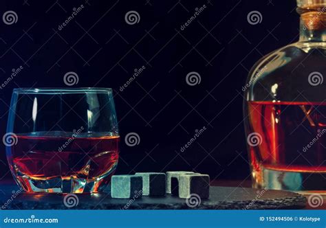 Vidro Do Conhaque Pedras Cinzentas E Frasco De XO Foto De Stock