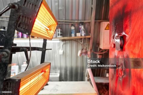 착색 테스트는 따뜻한 램프 아래에서 건조됩니다 차고 페인팅 자동차 서비스 도장 전에 샌딩 프라이머를 작업하여 사고 후 차체 작업을 수리합니다 산업에 대한 스톡 사진 및 기타