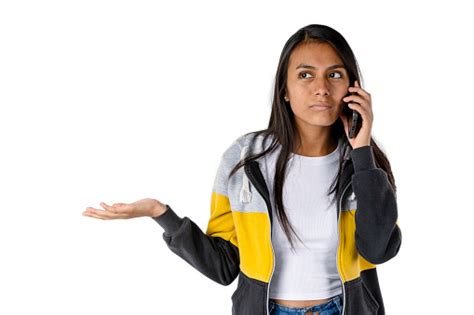 메시지를 듣거나 흰색 배경을 통해 휴대 전화에 그녀의 대담에 심각한 표정을 가진 매력적인 라틴 어 여성 기술 및 통신 개념 코포이 스페이스 18 19세에 대한 스톡 사진 및