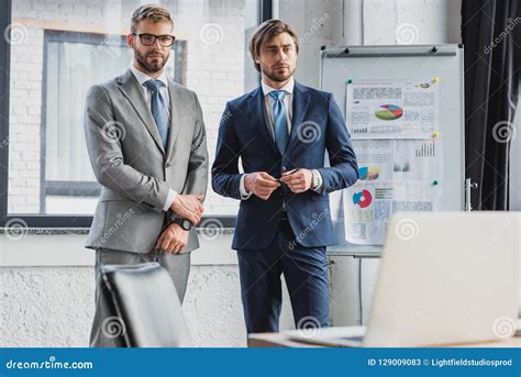 Three Handsome Young Businessmen In Suits Standing Together Stock Image
