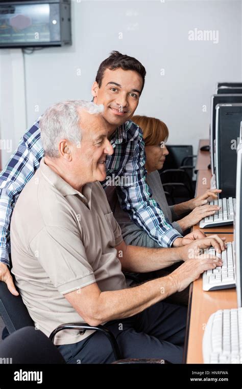 Tutor Helping Senior Man In Using Computer Stock Photo Alamy
