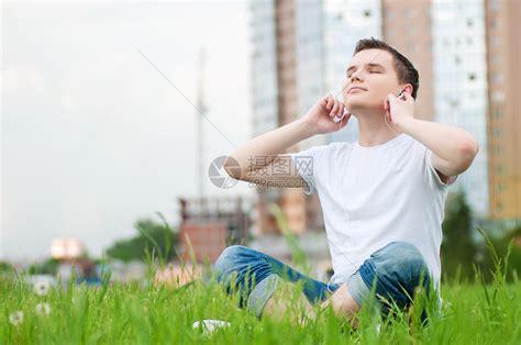 有耳机的有吸引力的年轻人闲暇自由天空假期乐趣蓝色美丽男生日光浴快乐高清图片下载 正版图片321585536 摄图网