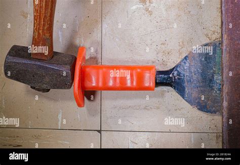A Club Hammer Hitting A Bolster Chisel To Loosen A Piece Of Wood Fixed