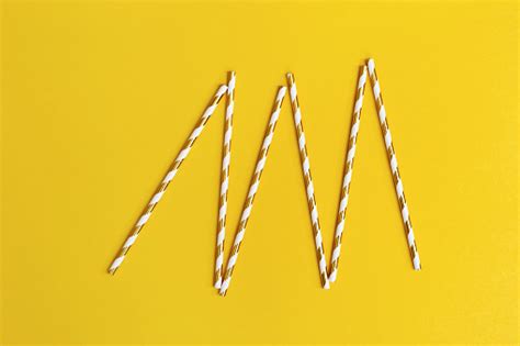 복사 공간이있는 노란색 배경에 흰색과 황금 줄무늬가있는 밝은 종이 마시는 빨대 휴일 이나 축 하에 대 한 개념입니다 플랫 레이 개념에 대한 스톡 사진 및 기타 이미지