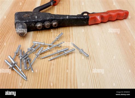 Closeup Of Pop Rivets And Riveter Tool On A Wooden Board Stock Photo Alamy