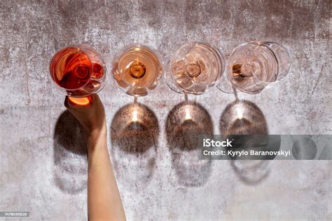 회색 배경에 서 있는 잔에 담긴 네 종류의 와인과 그 중 하나를 들고 있는 인간의 손 와인에 대한 스톡 사진 및 기타 이미지 와인 와인잔 샴페인 와인 Istock