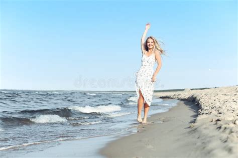 Happy Blonde Beautiful Woman Having Fun On Ocean Beach While Dancing In