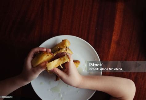 파인애플 한 조각을 먹는 어린 소년 접시와 과일을 잘라 테이블의 상단 보기 어두운 치료는 분위기와 몰입을 만듭니다 맛있는 음식의